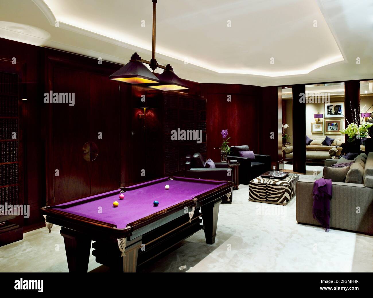 Spacious open plan room with purple pool table, armchairs and sofa in ...