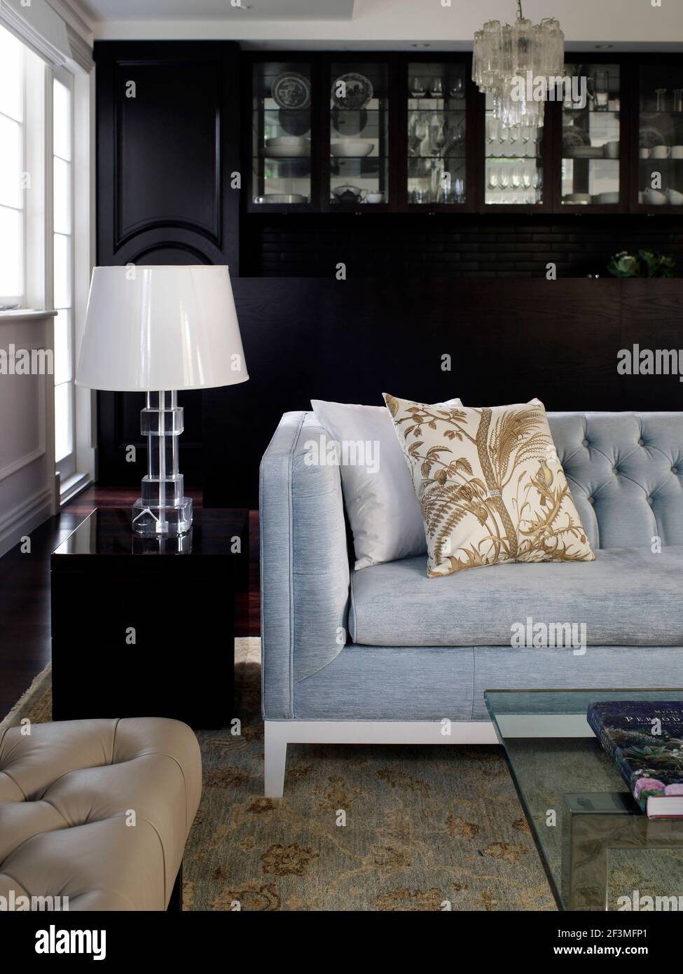 Lamp on side table next to sofa with cushions in residential house ...