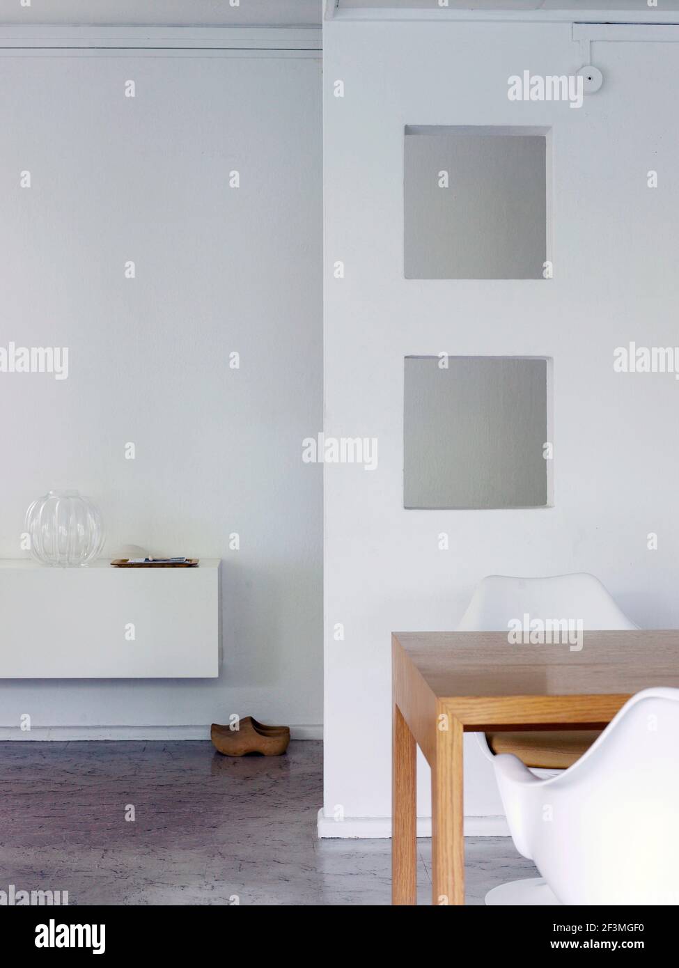 Wooden table and clogs in white interior, Singapore Stock Photo - Alamy