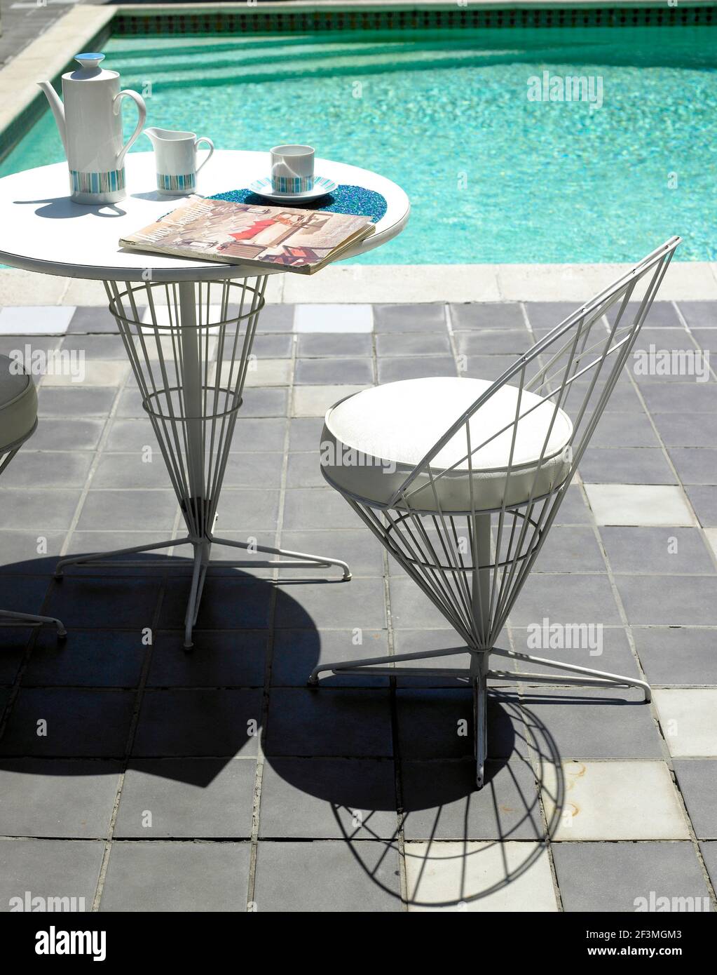 Metal table and chair at poolside of Californian home, USA Stock Photo ...