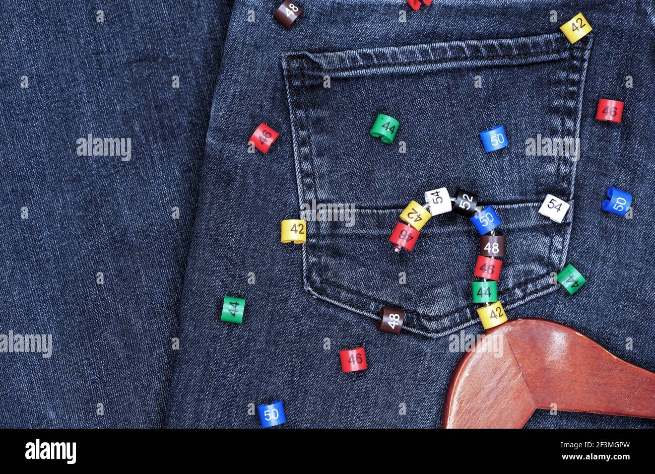 Clothes hangers with multicolored plastic size labels on a denim ...