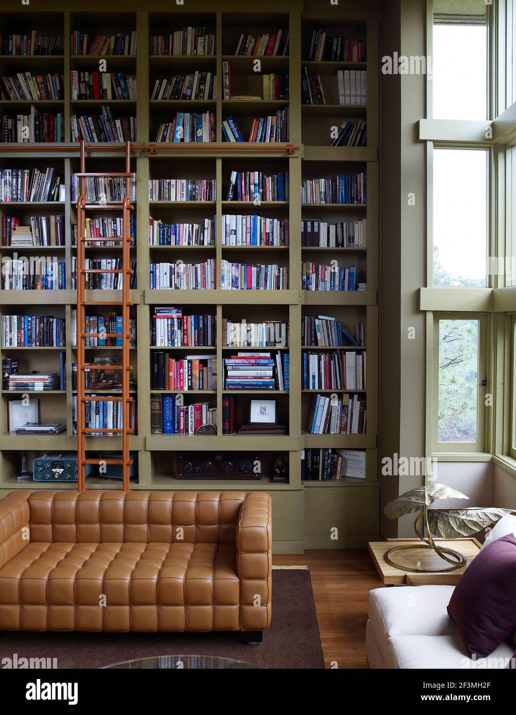 Bookcase in study with brown leather sofa in California home, USA Stock ...