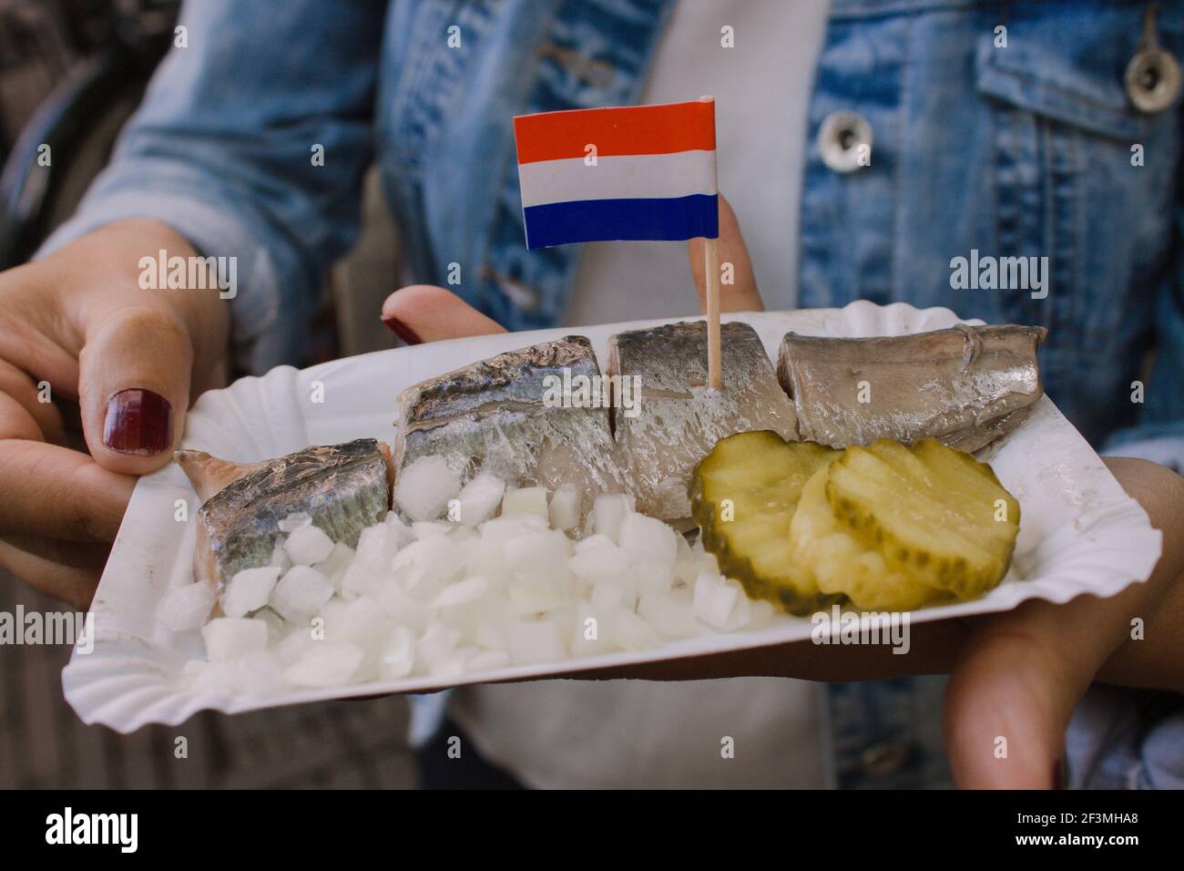The traditional dutch herrings with Netherlands flag, green pickles ...