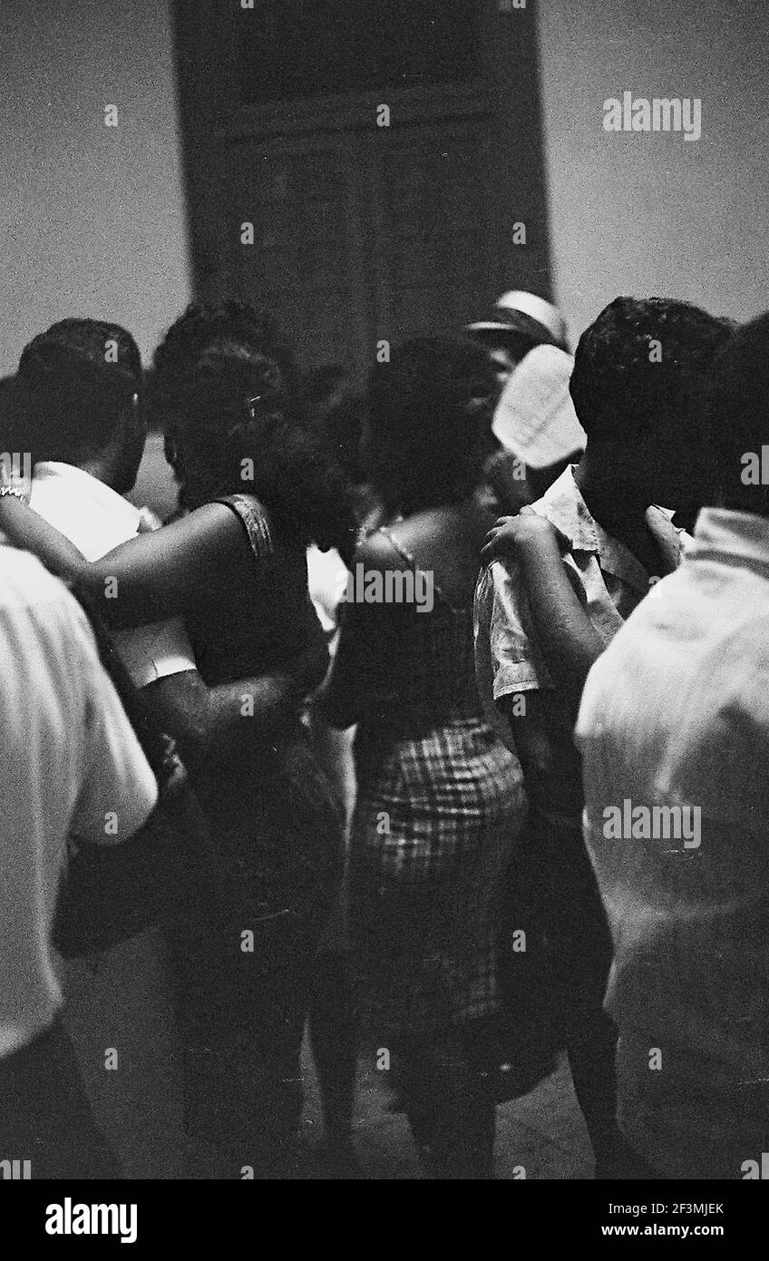 Two women, from the back, wearing strappy, fitted dresses, dancing in a ...