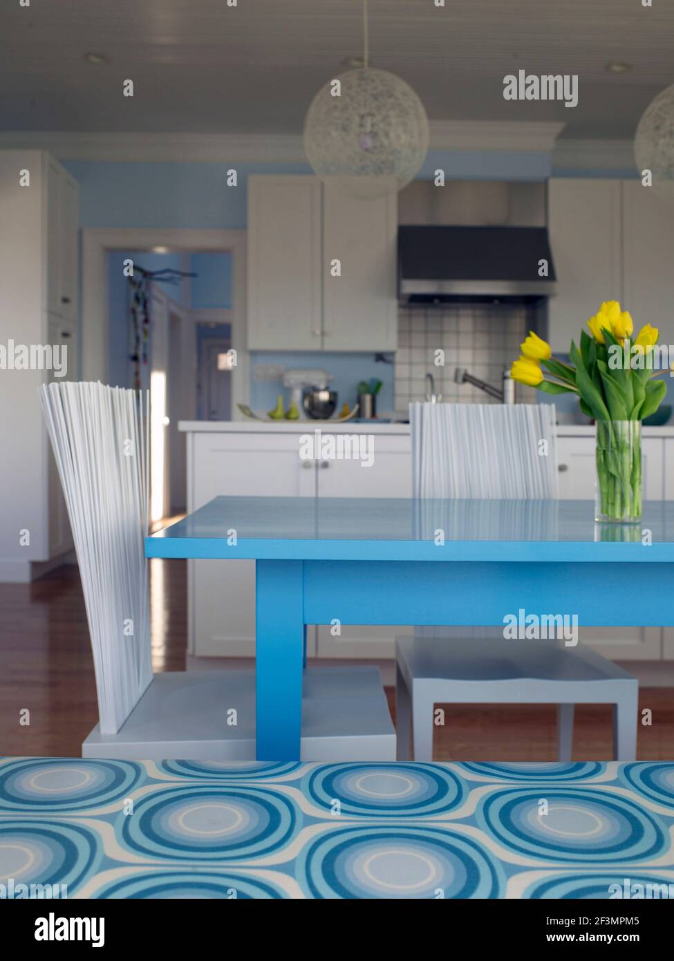 Blue dining table in open plan kitchen in New York home Stock Photo - Alamy