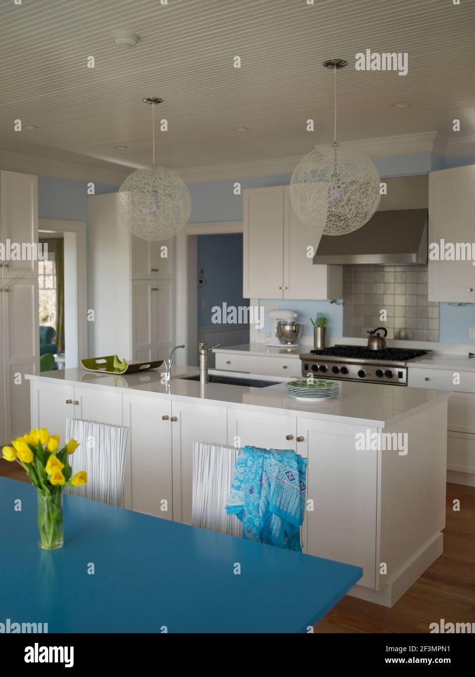 Blue dining table in open plan kitchen in New York home Stock Photo - Alamy