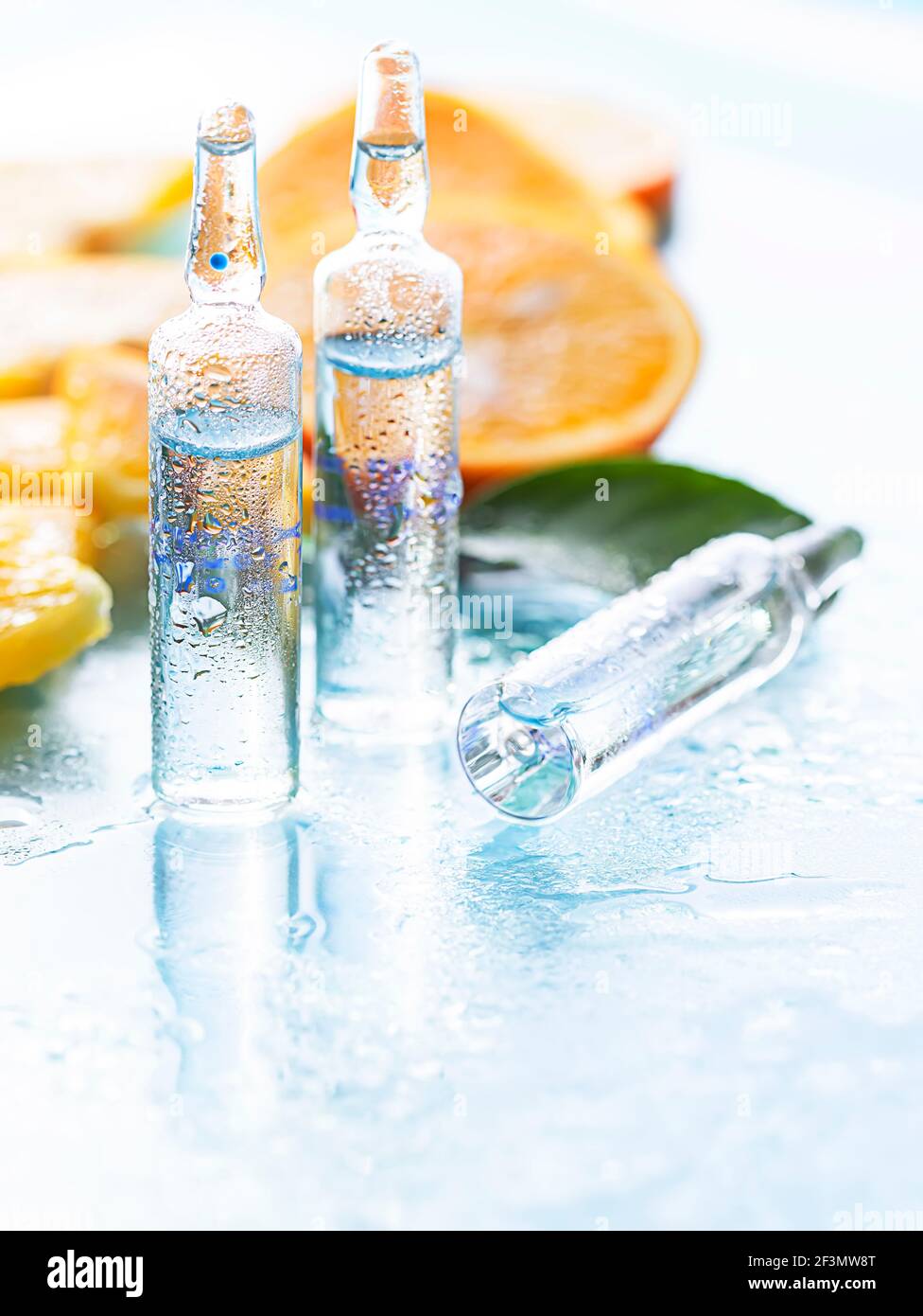 Ampoule with vitamin C for injection and fresh citrus fruits. Natural ...