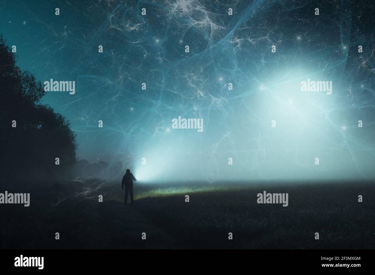 A science fiction concept of a man standing in a spooky field in the ...