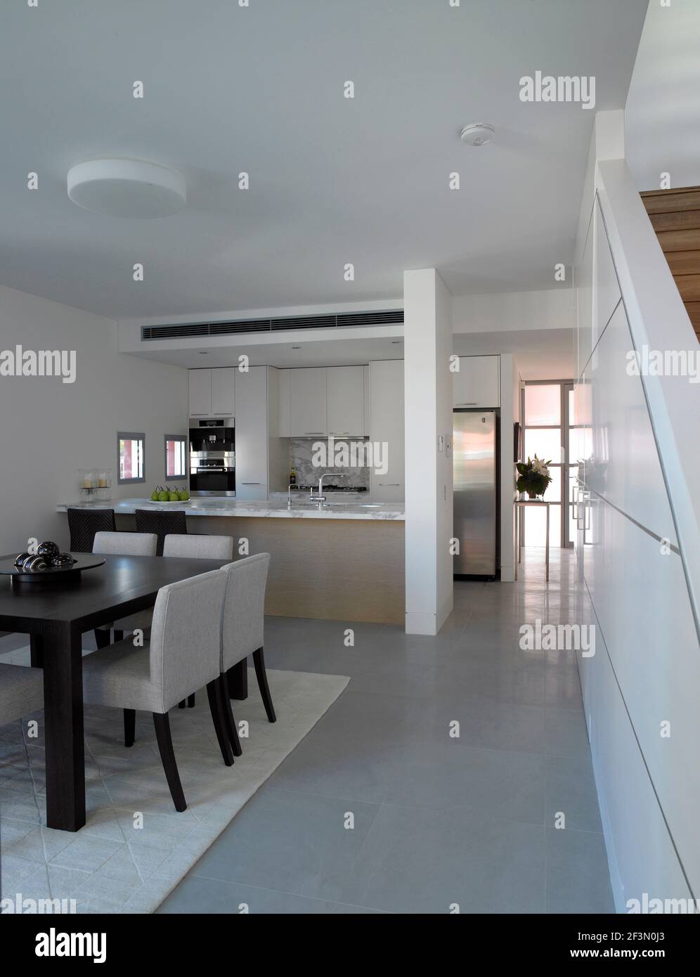 Table and chairs in open plan kitchen with breakfast bar unit ...