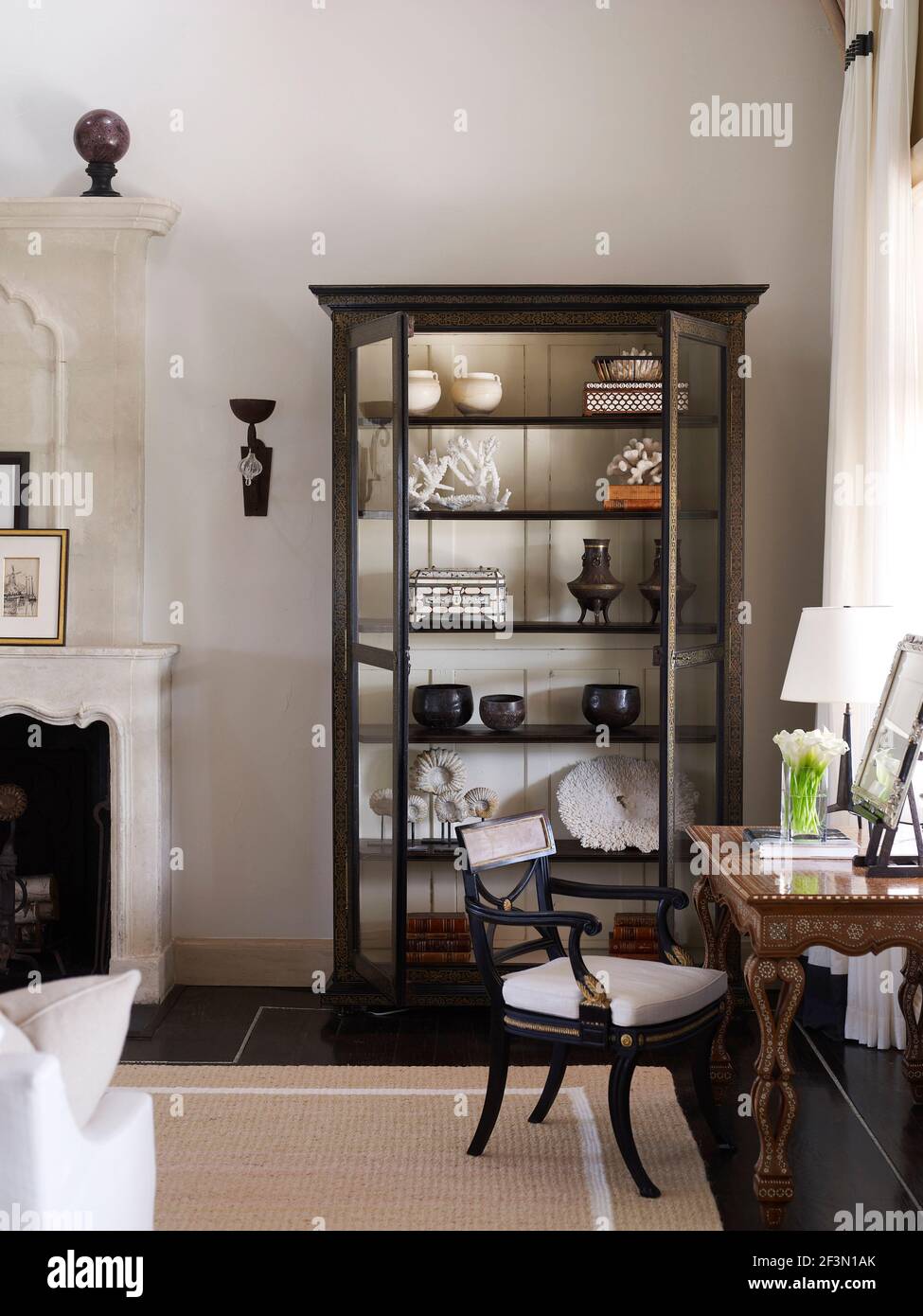 Table and chair in front of display cabinet in living room in USA home ...