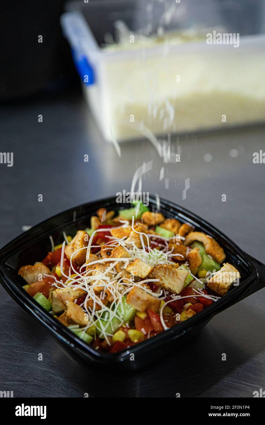 An unrecognizable chef adding cheese to a fresh delicious salad in a ...