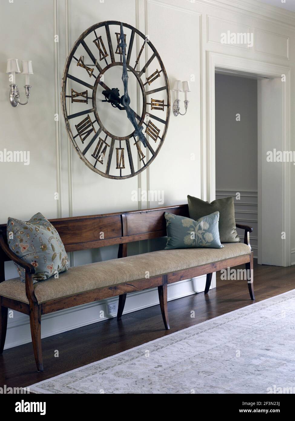 Large clock above antique wooden bench seat in Shelley Morris Designed ...