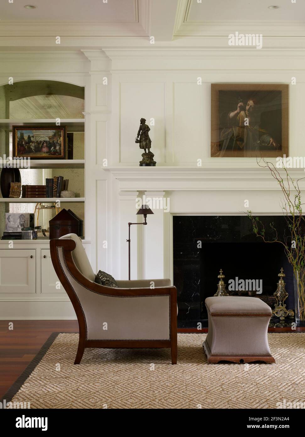 Armchair and footstool at fireplace in traditional US home Stock Photo ...