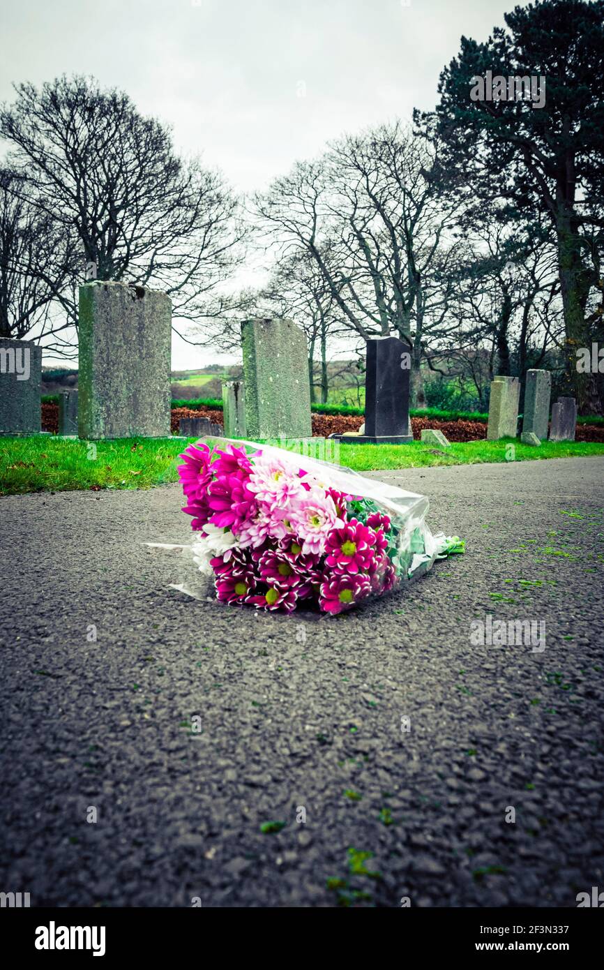 A bouquet of flowers dropped on a path in cemetery Stock Photo - Alamy