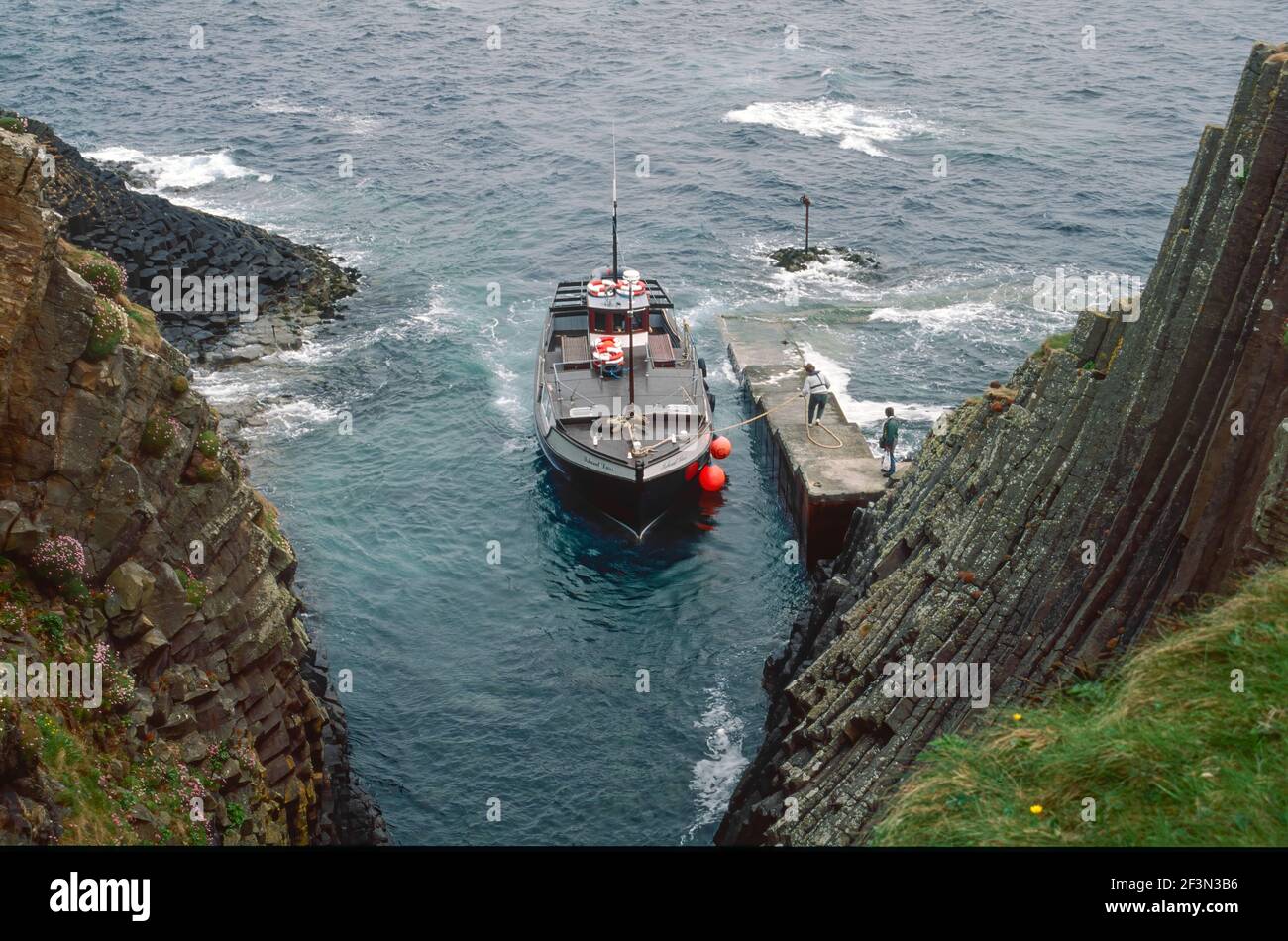 Tourist boat at the landing stage on The Isle of Staffa, Scotland Stock ...