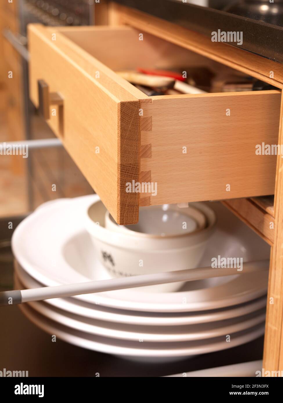 Open drawer with tableware below Stock Photo - Alamy