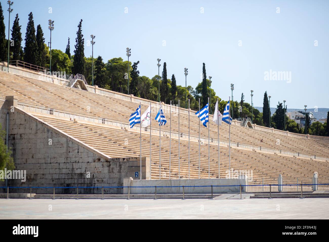 The Main Olympic Stadium surrounded by trees under a blue sky and ...