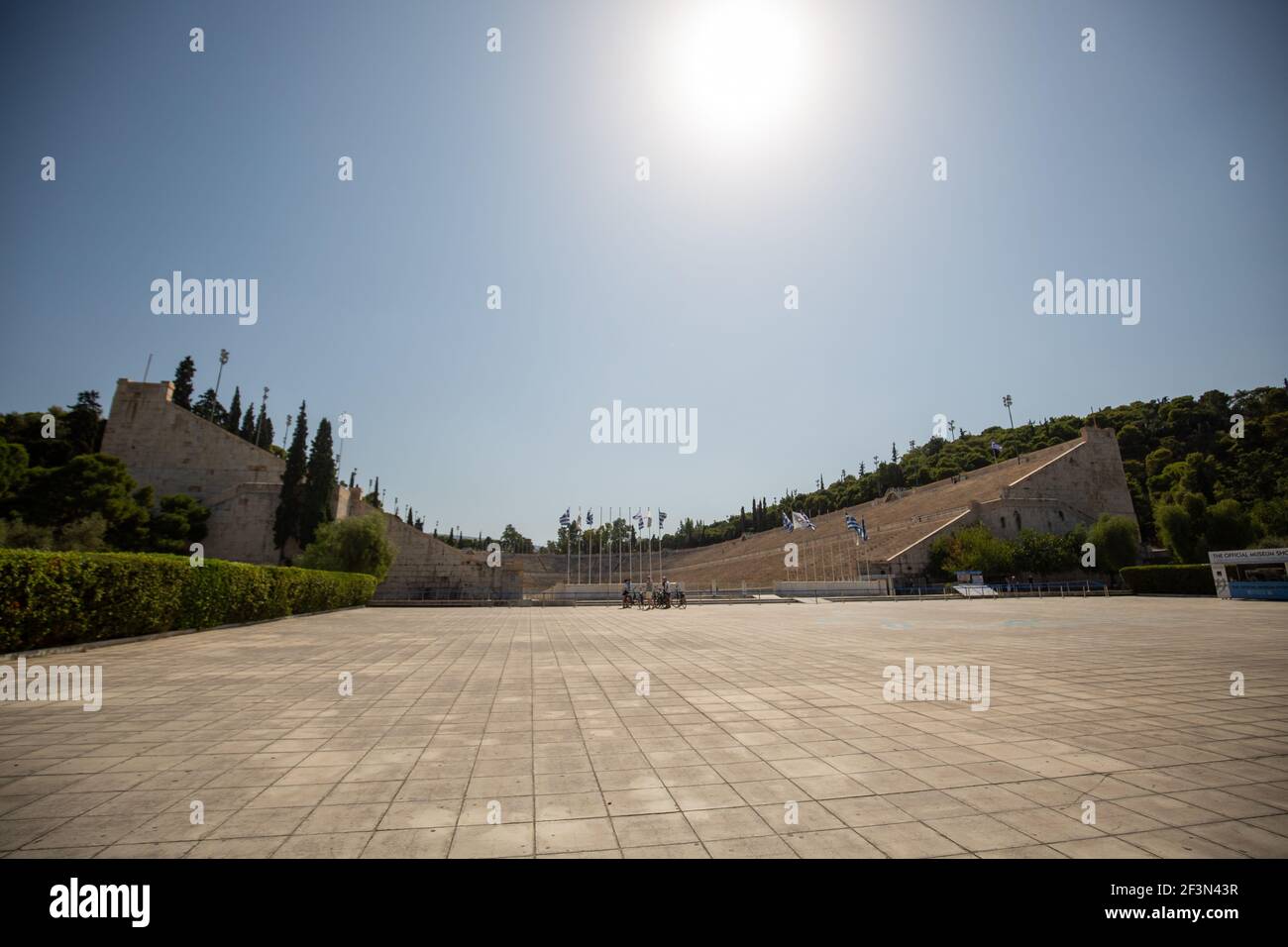 The Main Olympic Stadium surrounded by trees under a blue sky and ...