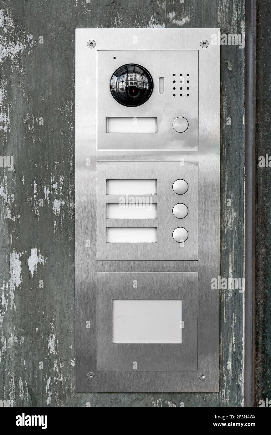 gray iron intercom with call buttons and a camera with a speaker ...