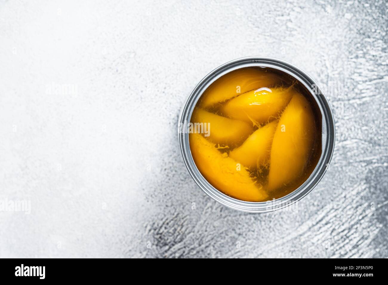 Canned mango slices in syrup in a metal can. White background. Top view ...