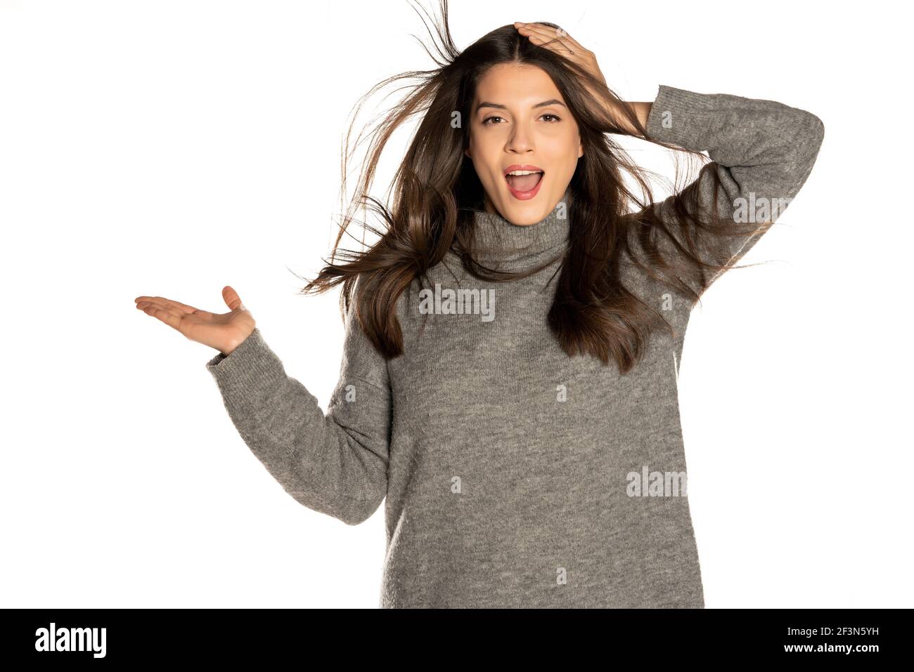 young beautiful woman holding imaginary object on her hand on white ...