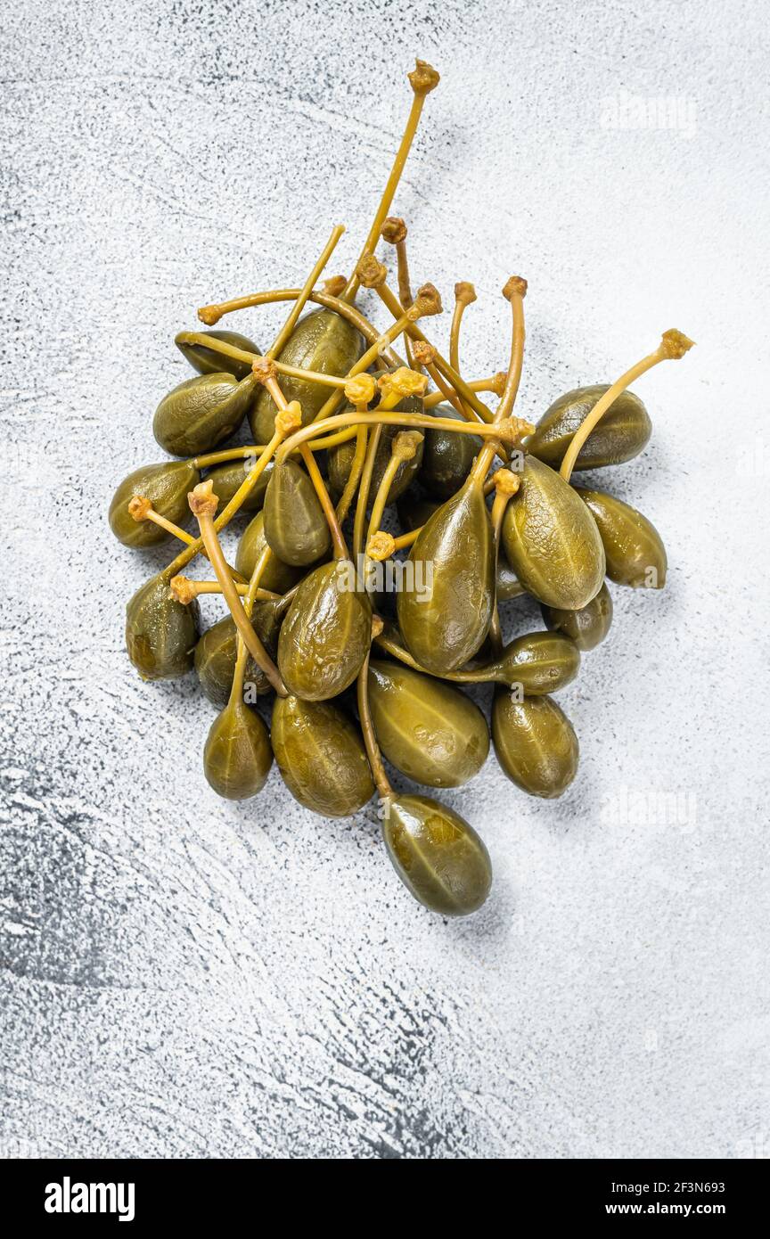 Pickled capers on a kitchen table. White background. Top view Stock ...