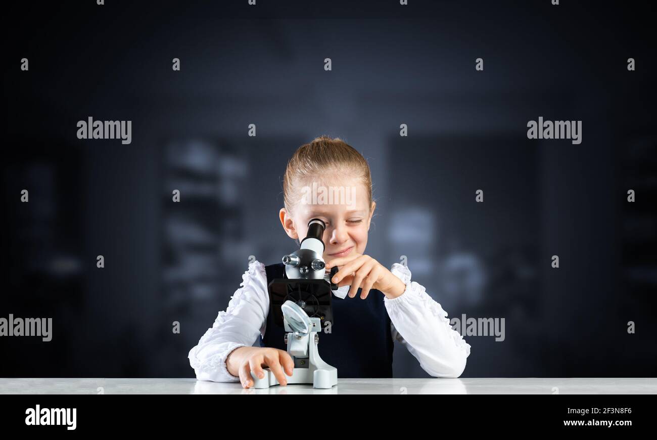 Little scientist looking through microscope Stock Photo - Alamy