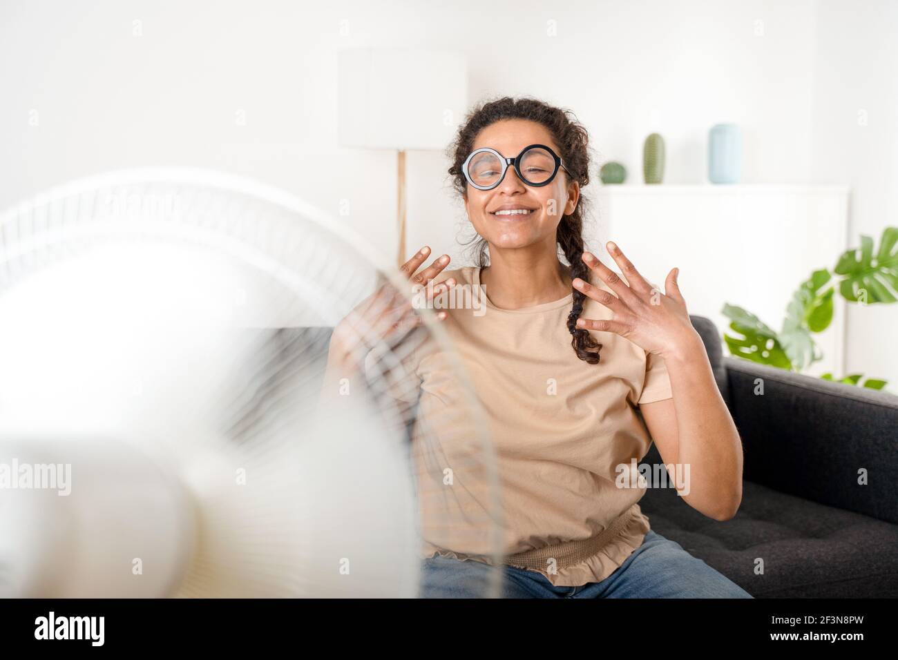 Black woman refreshing from summer heat at home Stock Photo - Alamy