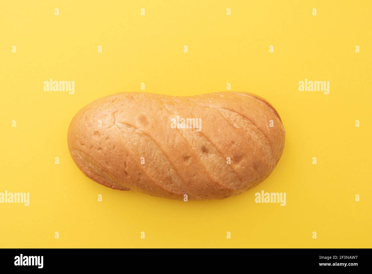 Loaf, white bread, baton on yellow surface, top view, lay out, space ...