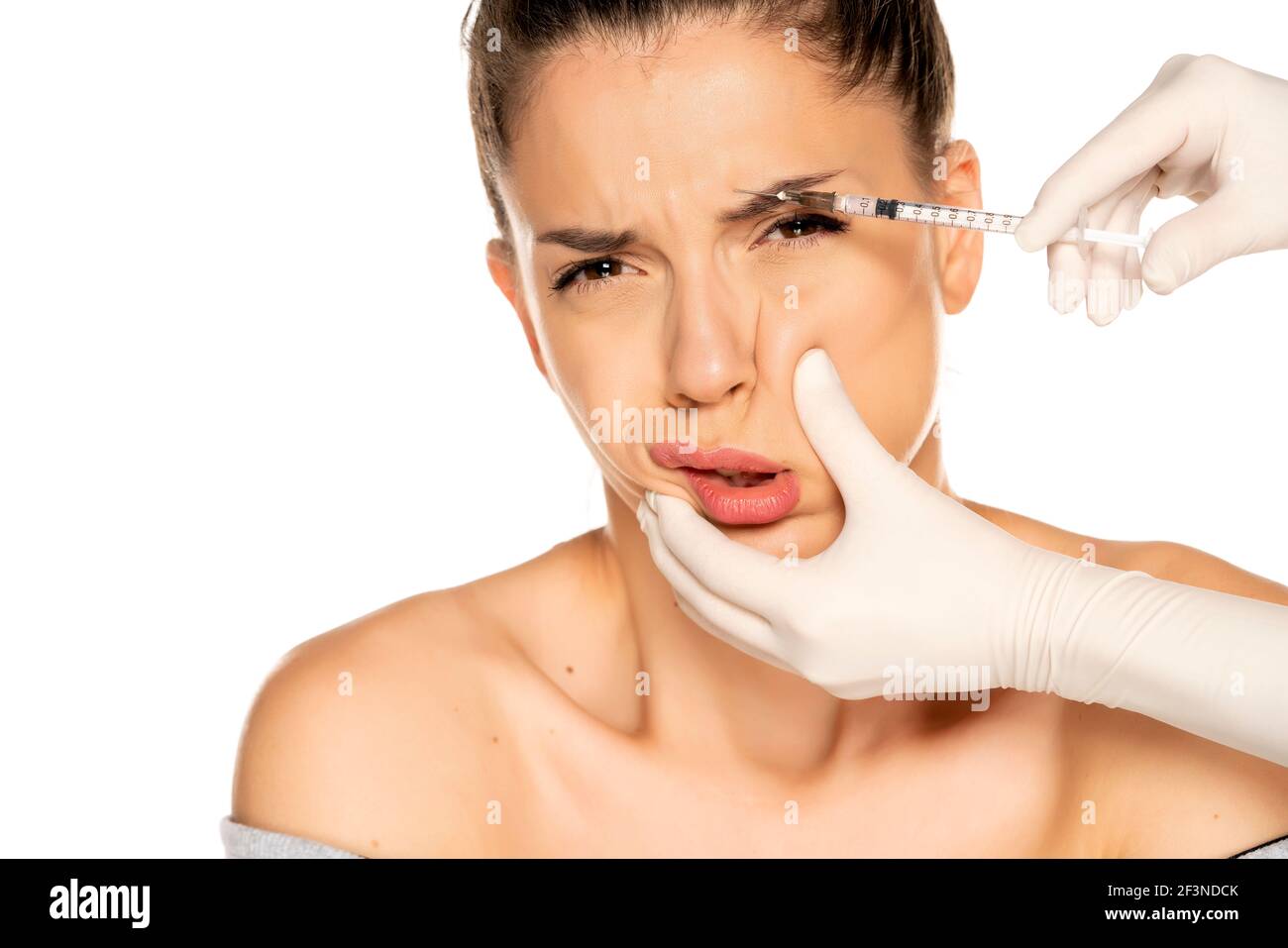 Portrait of a young frightened woman on a face filler injection ...