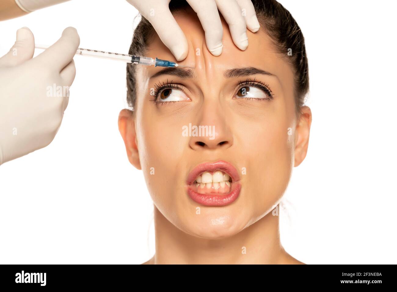 Portrait of a young scared woman on a faace filler injection procedure ...