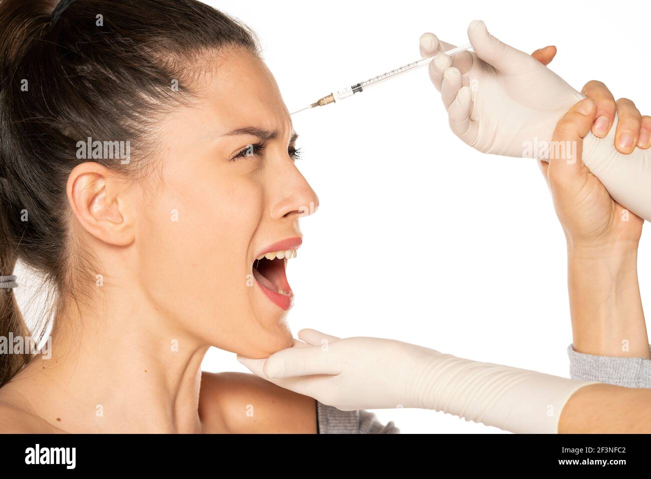 Portrait of a young frightened woman on a face filler injection ...