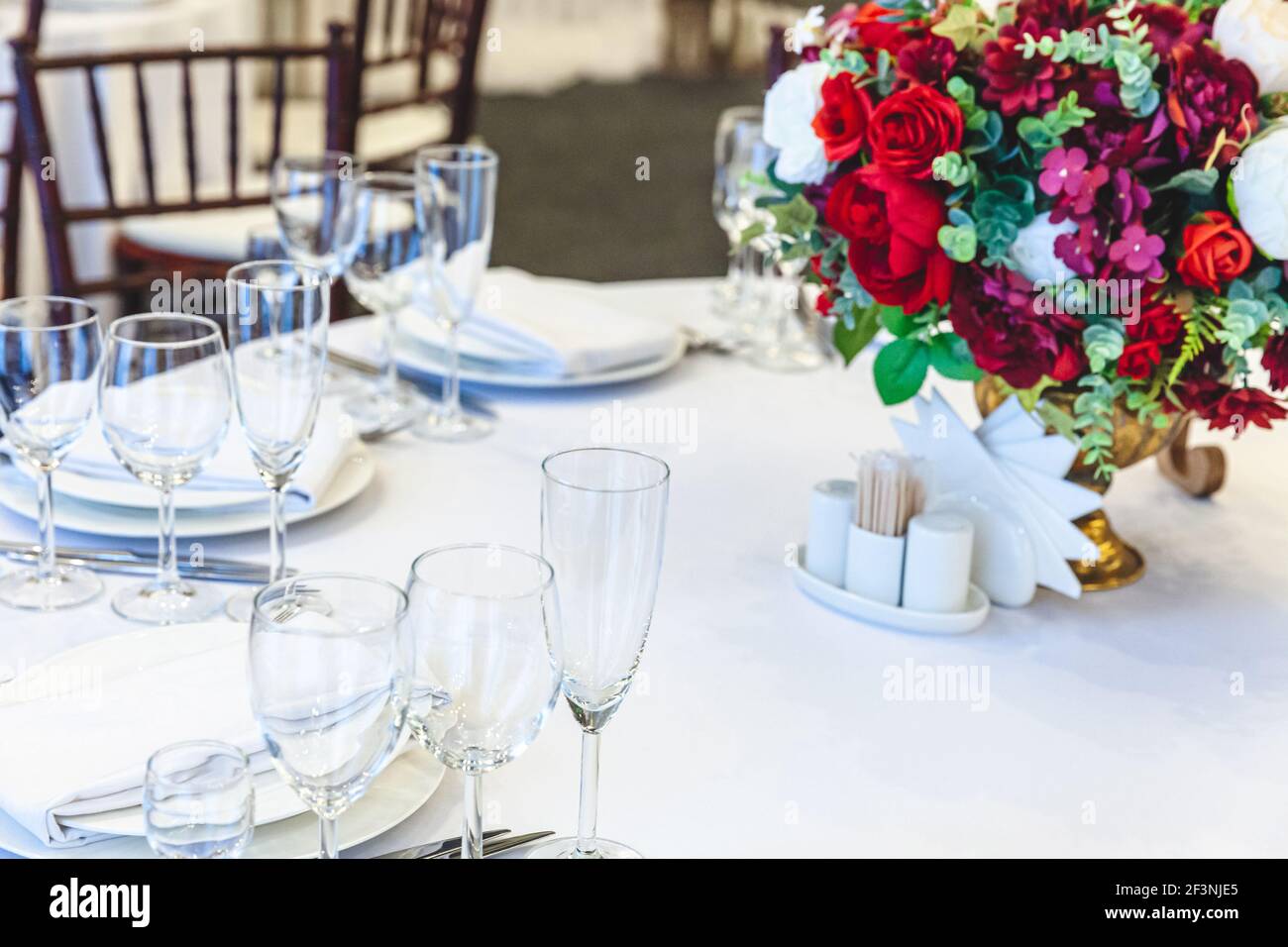 Fancy table set for dinner with flower composition in restaurant ...