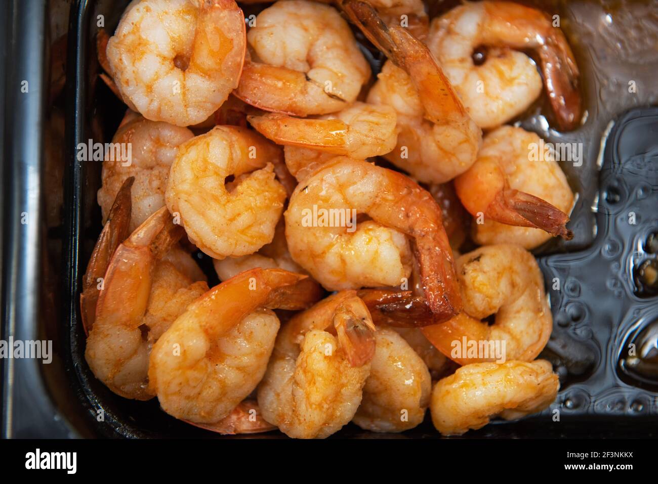 Pickled shrimp in black plastic container closeup Stock Photo - Alamy