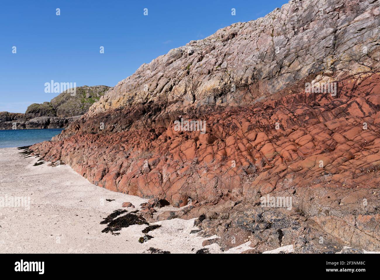 Port Ban, the white sands bay, on Iona, Scotland. Red rock geology and ...