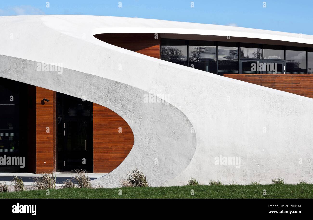 A dramatic white curved outer structure around a building which offers ...