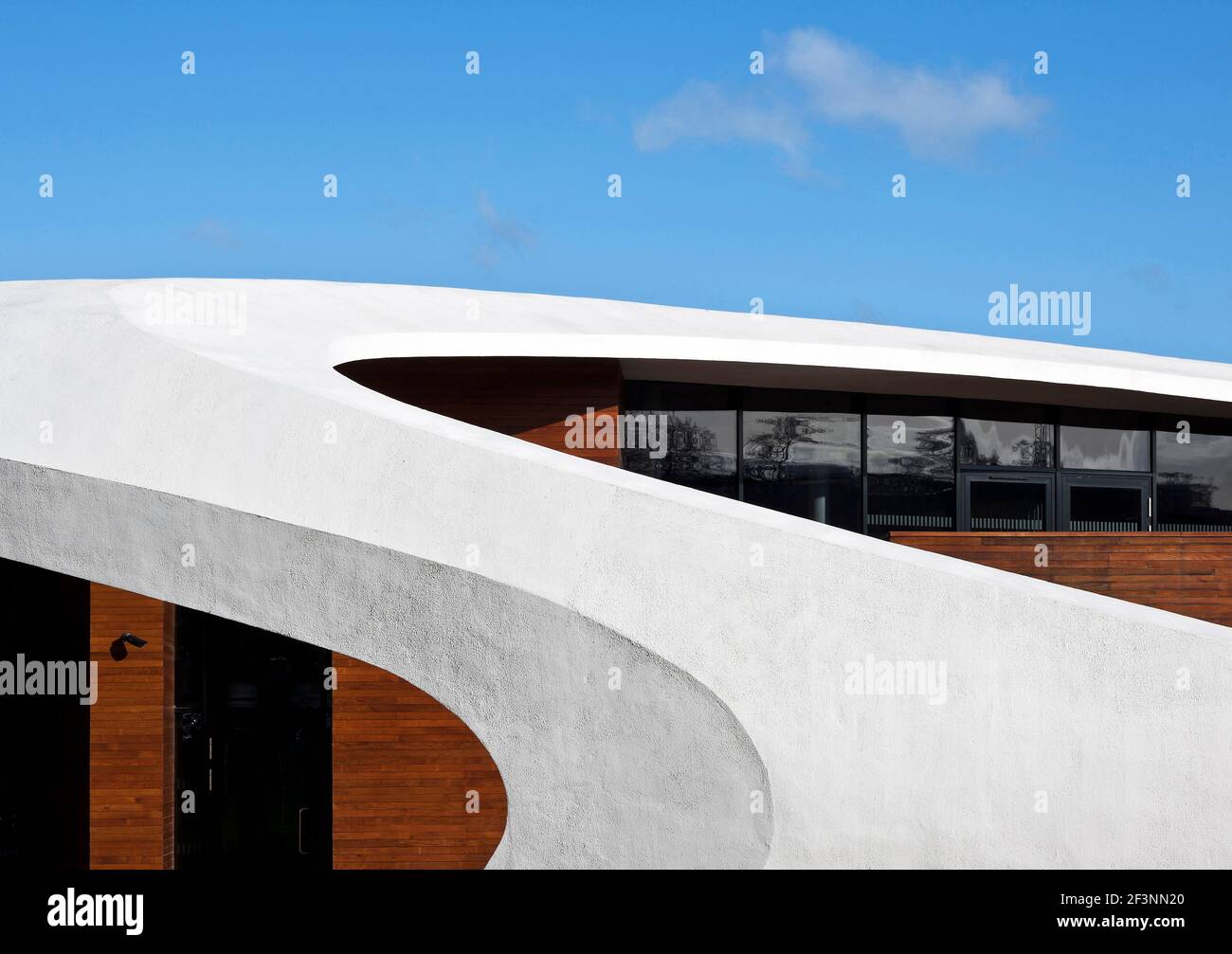 A dramatic white curved outer structure around a building which offers ...