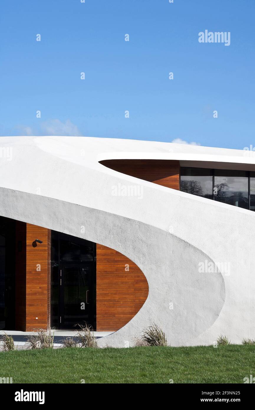 A dramatic white curved outer structure around a building which offers ...