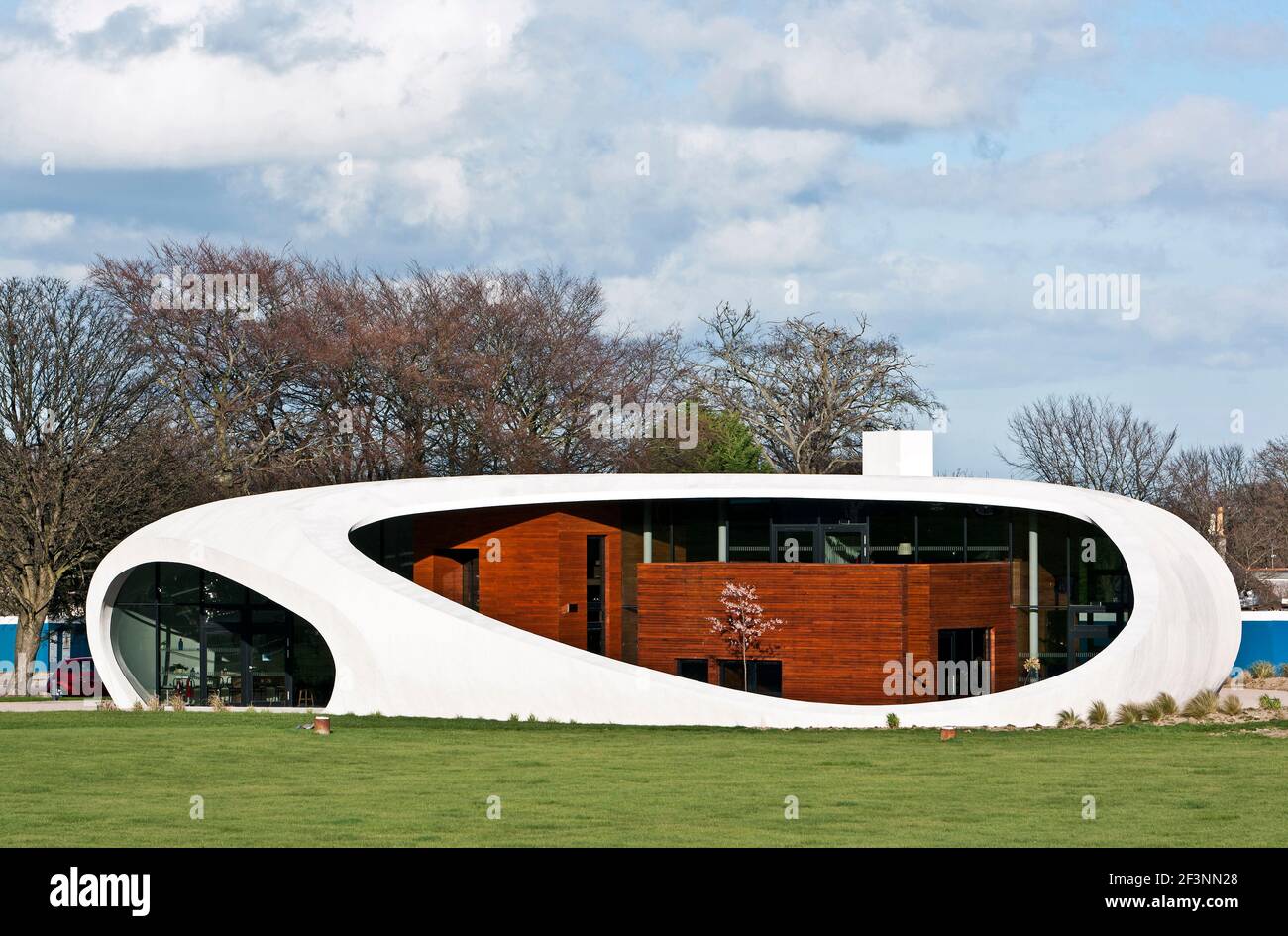 A dramatic white curved outer structure around a building which offers ...