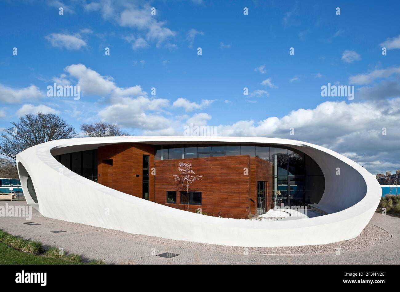 A dramatic white curved outer structure around a building which offers ...