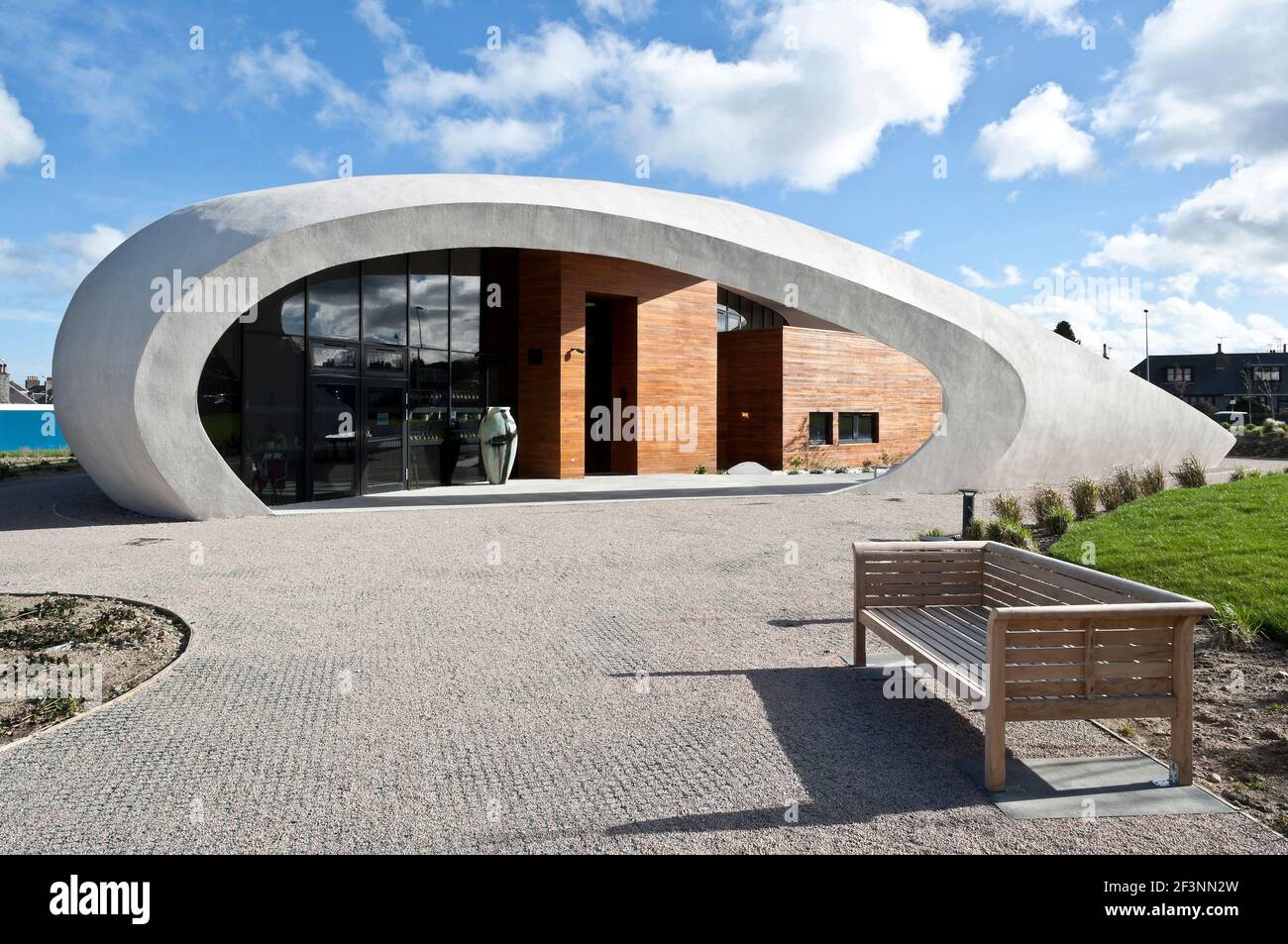 A dramatic white curved outer structure around a building which offers ...