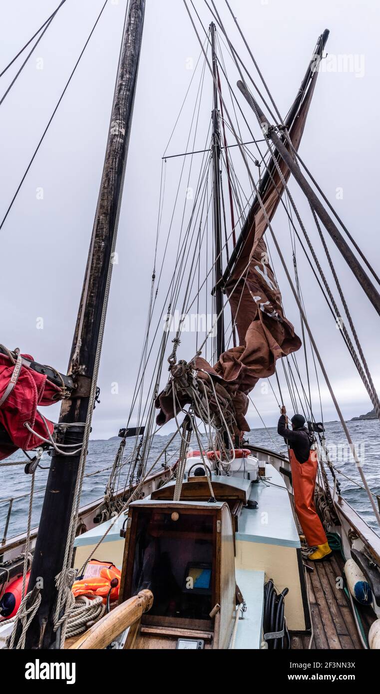Hauling up the mainsail of the ketch Birthe Marie, isle of Iona ...
