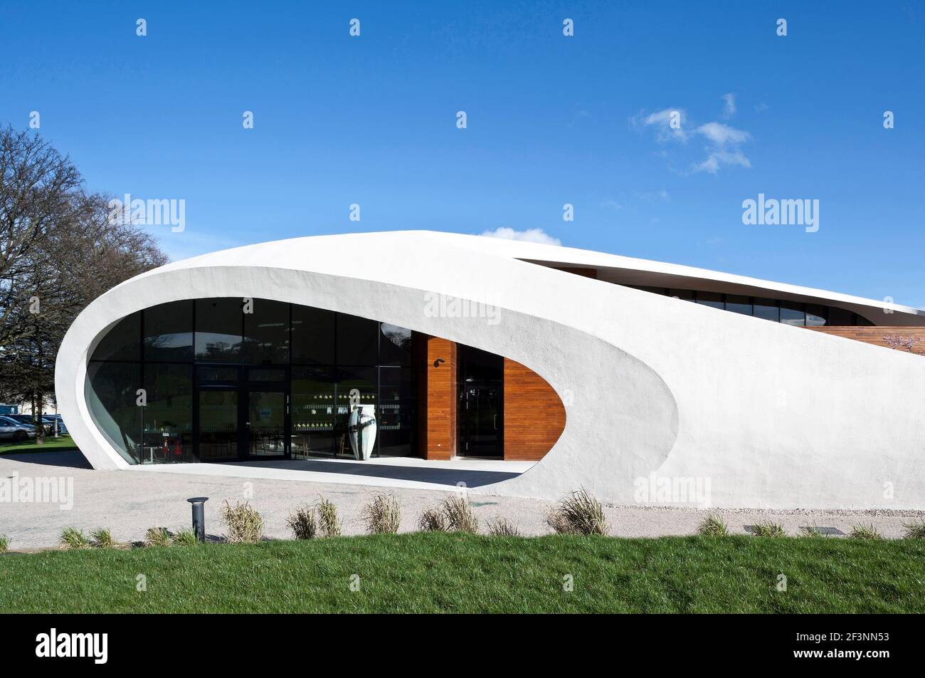 A dramatic white curved outer structure around a building which offers ...