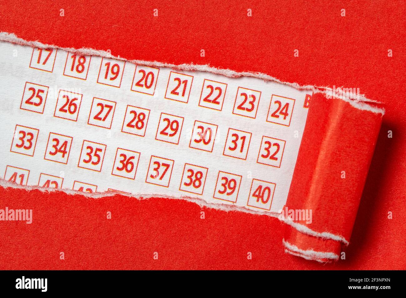 Red paper torn to reveal lottery ticket numbers. Conceptual image Stock ...