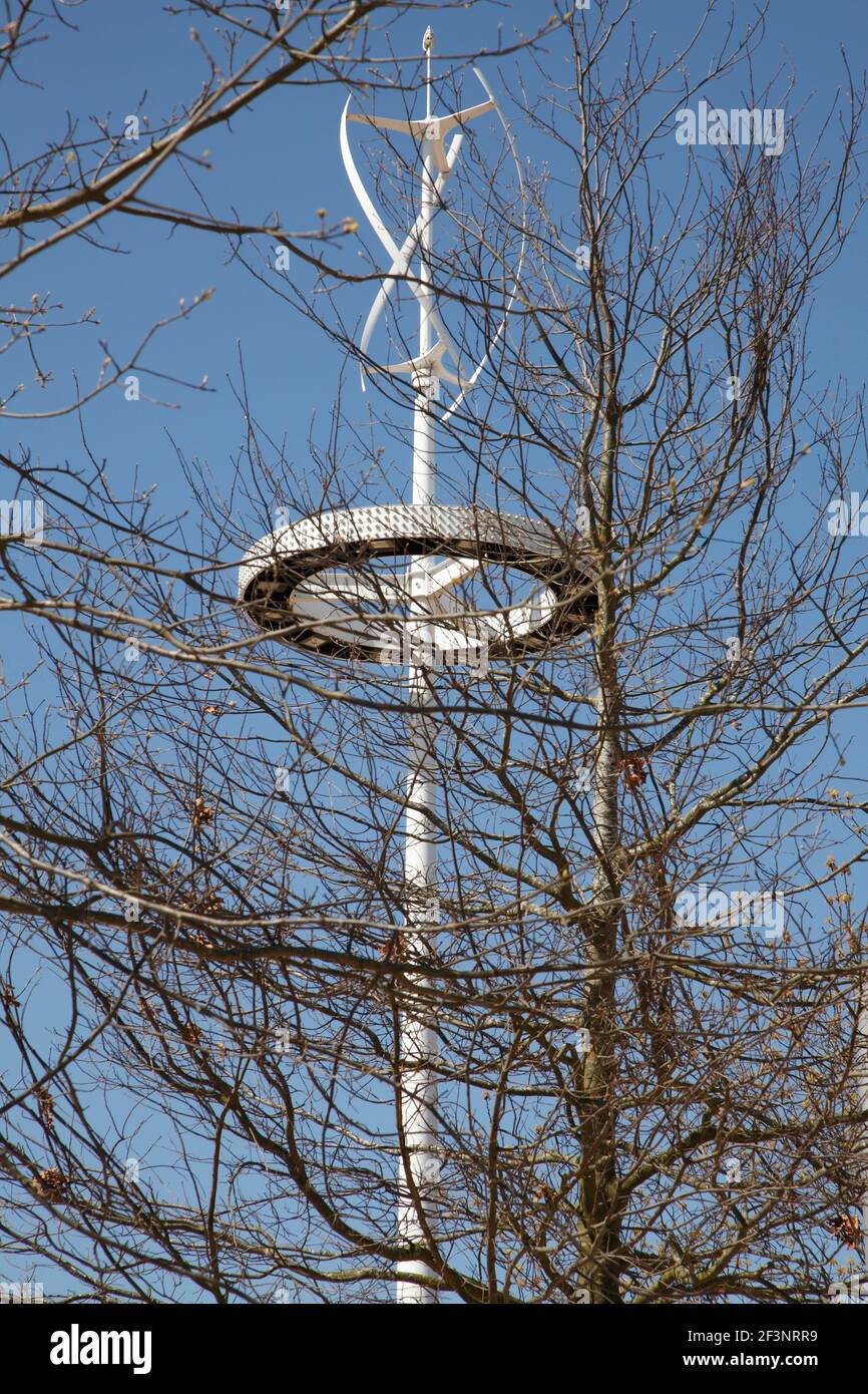 Wind turbine/lighting tower seen through trees | Architect: Unknown ...