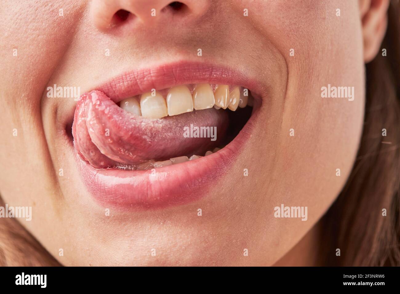 Beautiful young woman leaking teeth with tongue close-up Stock Photo ...