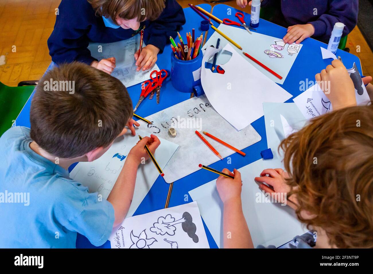 Primary school children writing on a desk during a lesson Stock Photo ...