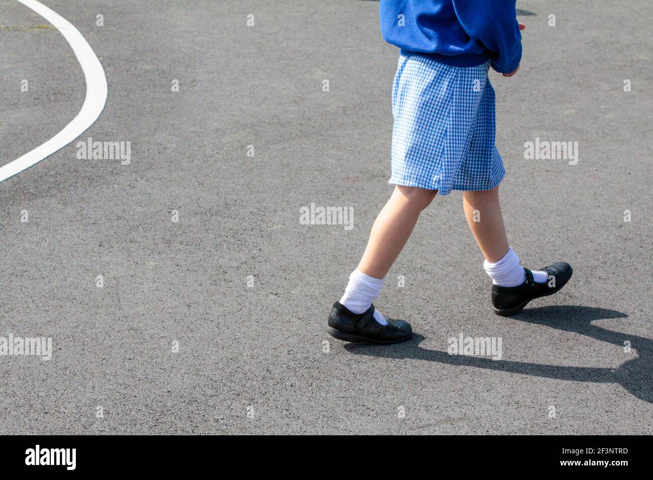 Primary school girl playing in a school playground in a break between ...
