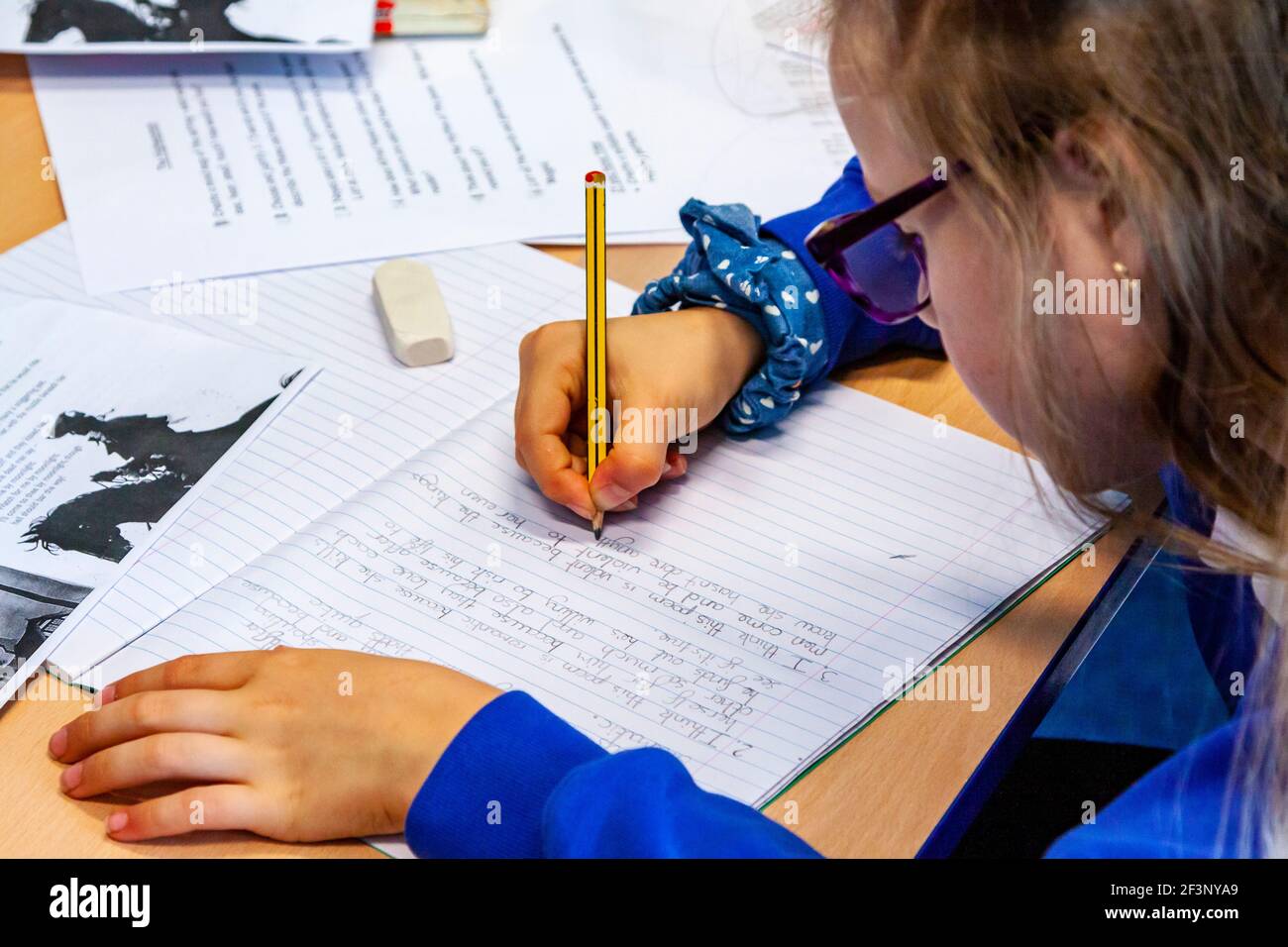 Primary school child writing on a desk during a lesson Stock Photo - Alamy