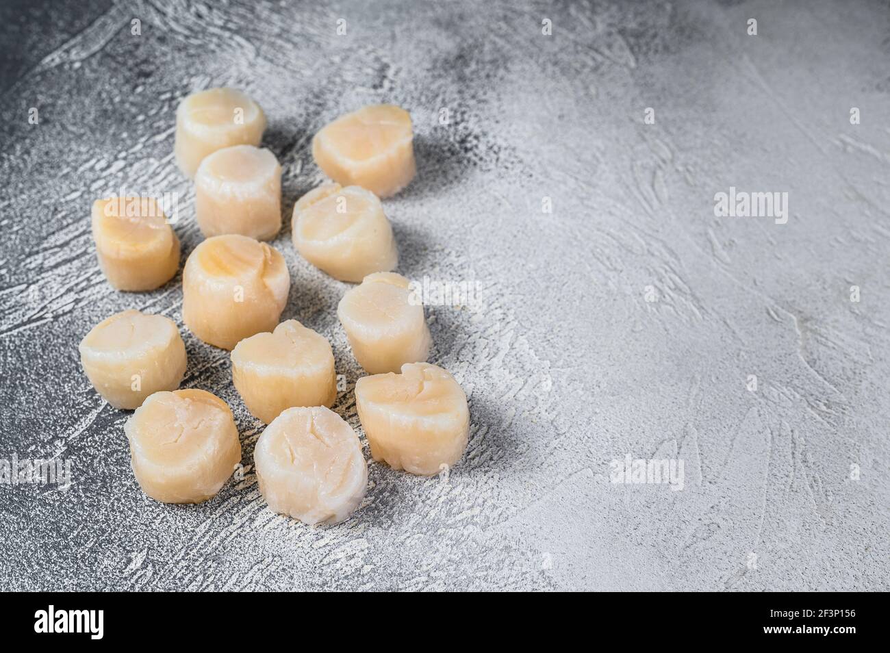 Raw scallops meat on a kitchen table. White background. Top view. Copy ...